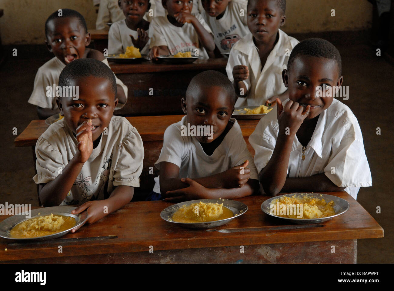 Schoolchildren eat with their hands at lunch time in a primary ...