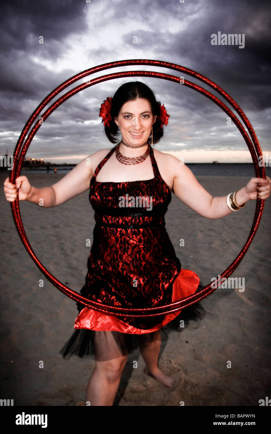 Circus performer with hula hoops on beach Stock Photo - Alamy