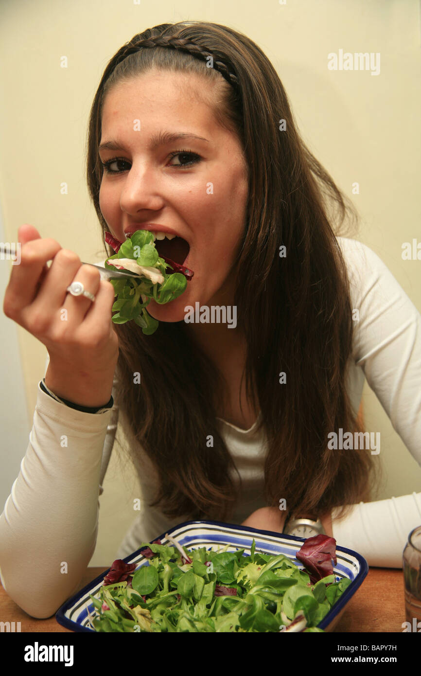 Teenage girl eating salad Stock Photo - Alamy