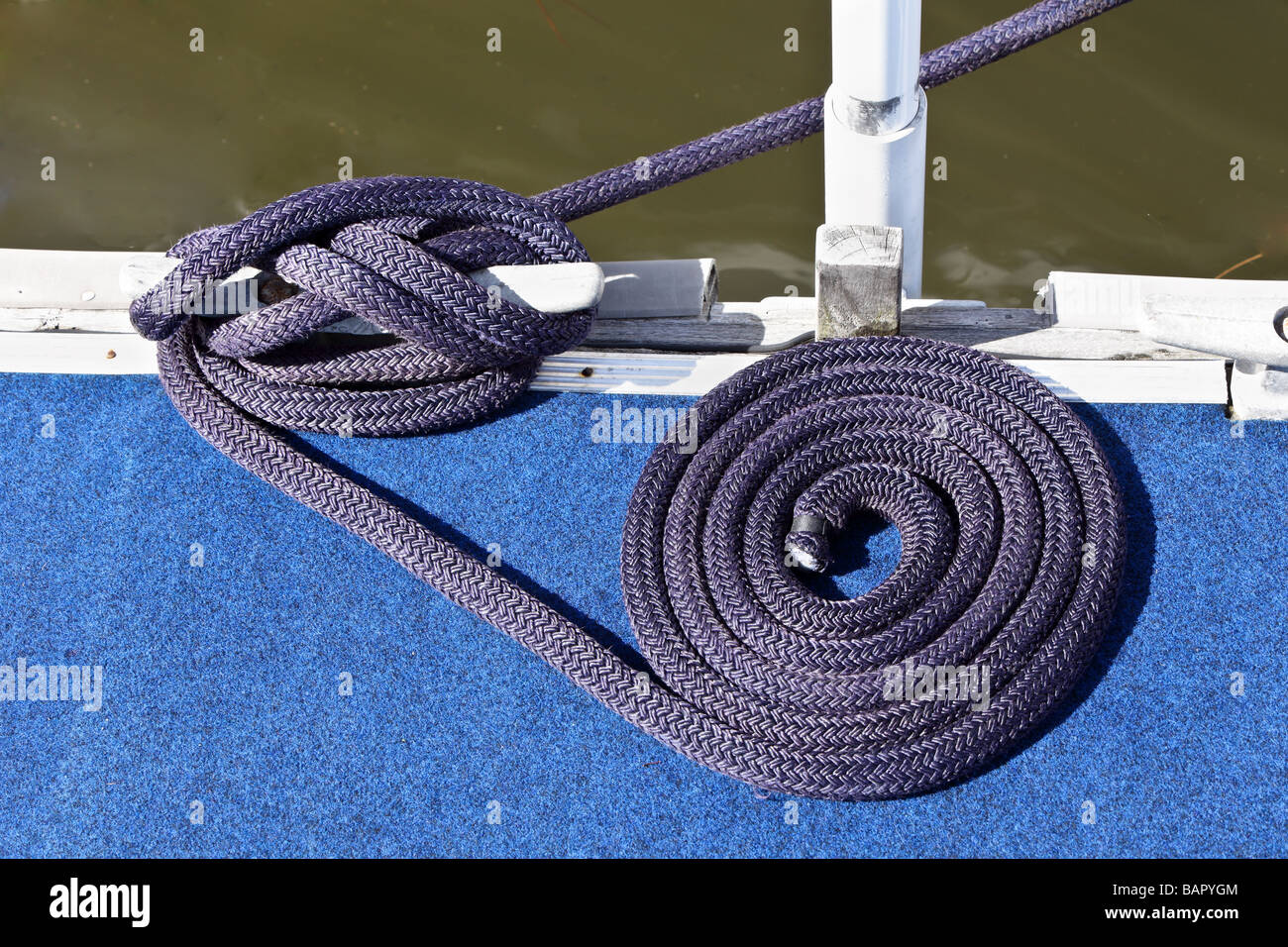 Boat tied up at a dock with mooring rope on bollard Stock Photo - Alamy