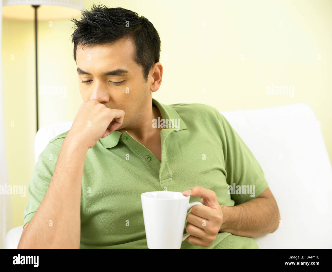 man holding a coffee cup thinking Stock Photo - Alamy