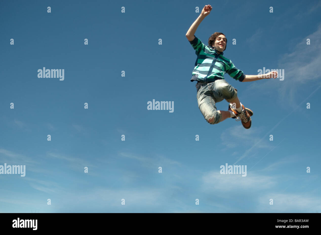 Teenage boy jumping high into the sky Stock Photo - Alamy