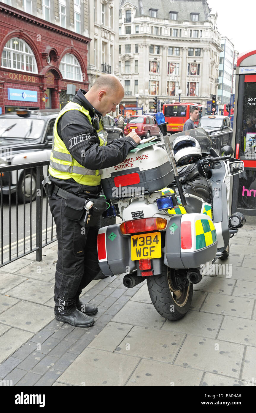 Motorcycle paramedic writing up notes Oxford Street London England UK ...