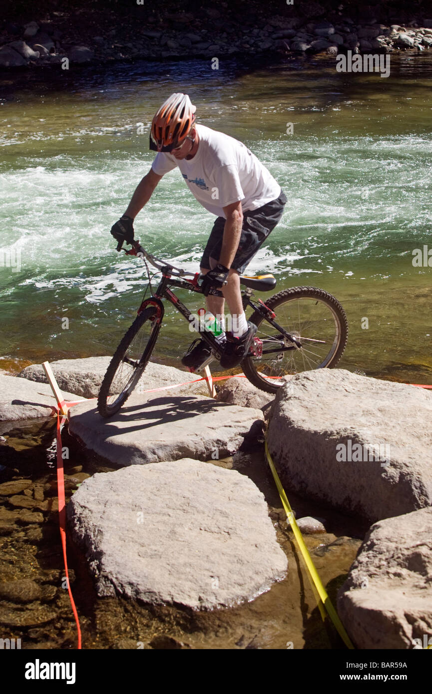 Competitor riding a mountain bike through an obstacle course during a ...