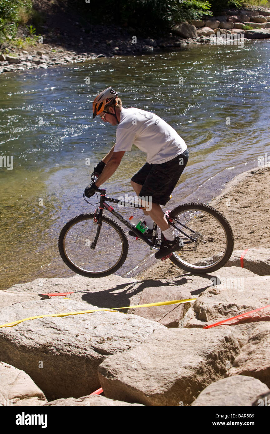 Competitor riding a mountain bike through an obstacle course during a ...