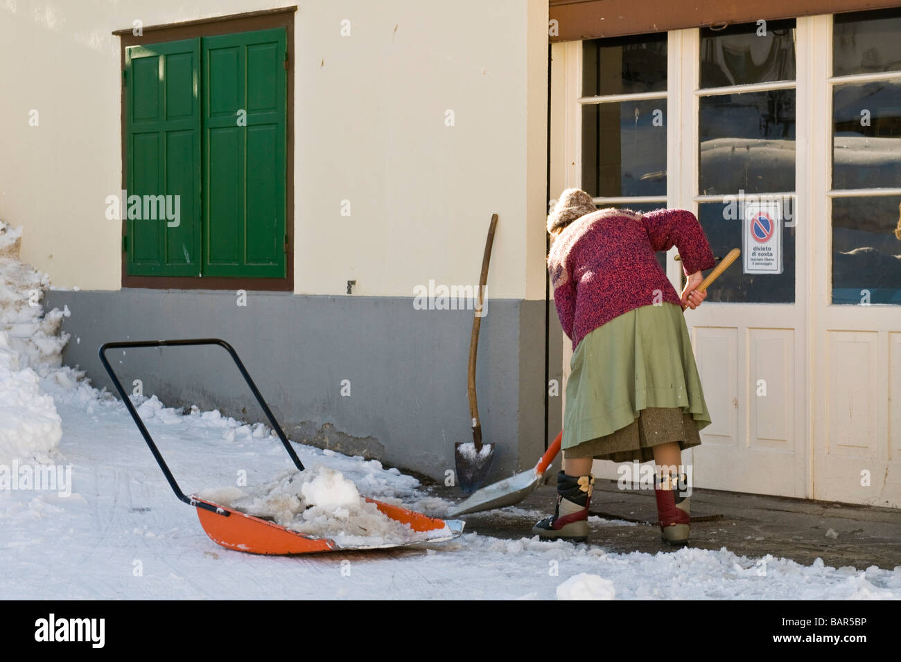Elderly woman shoveling snow hi-res stock photography and images - Alamy