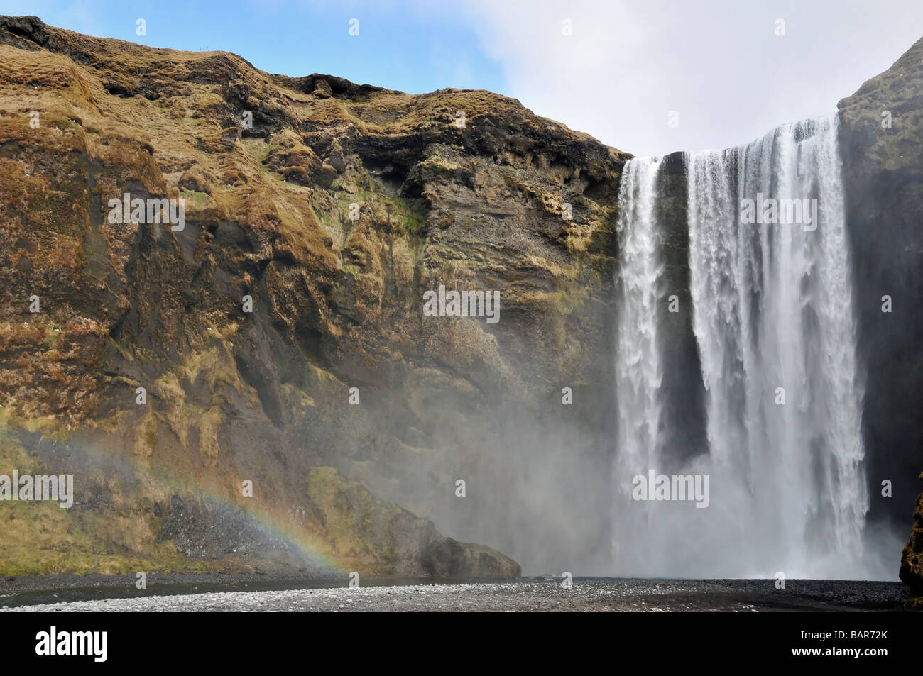 Wide angle frontal view, of the Skogafoss waterfall, with a rainbow in ...