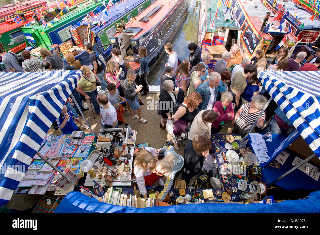 Busy sidewalk market stall by canal selling antiques and other items ...