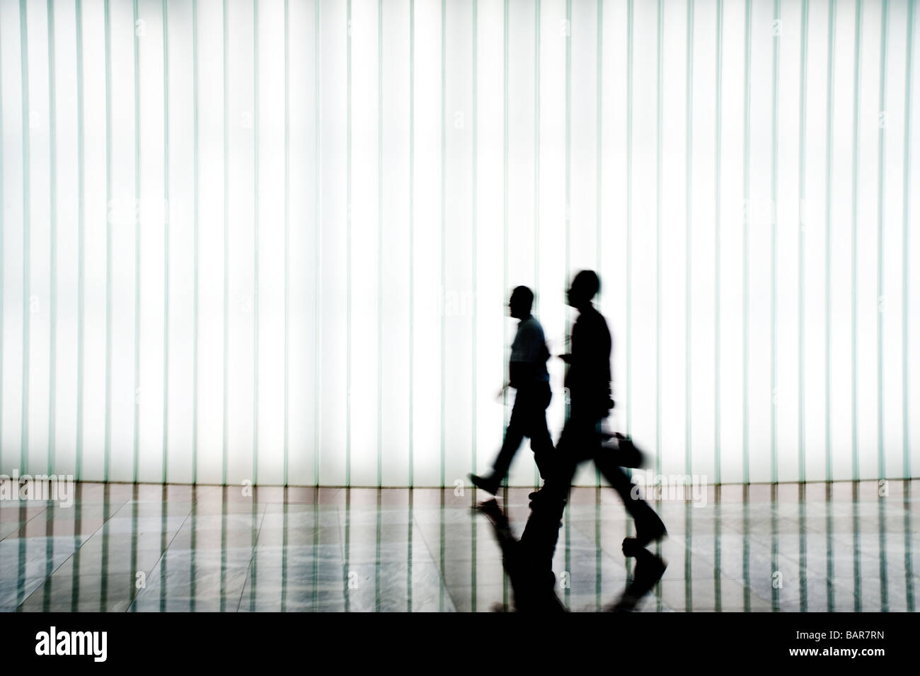 Person walking in silhouette against a white patterned background Stock ...