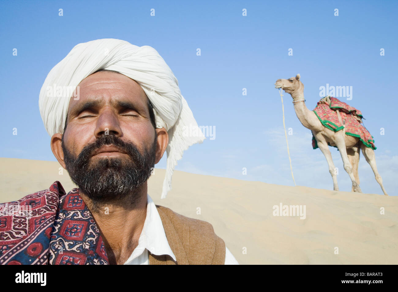 Close-up of a man with a camel in the background, Thar Desert ...