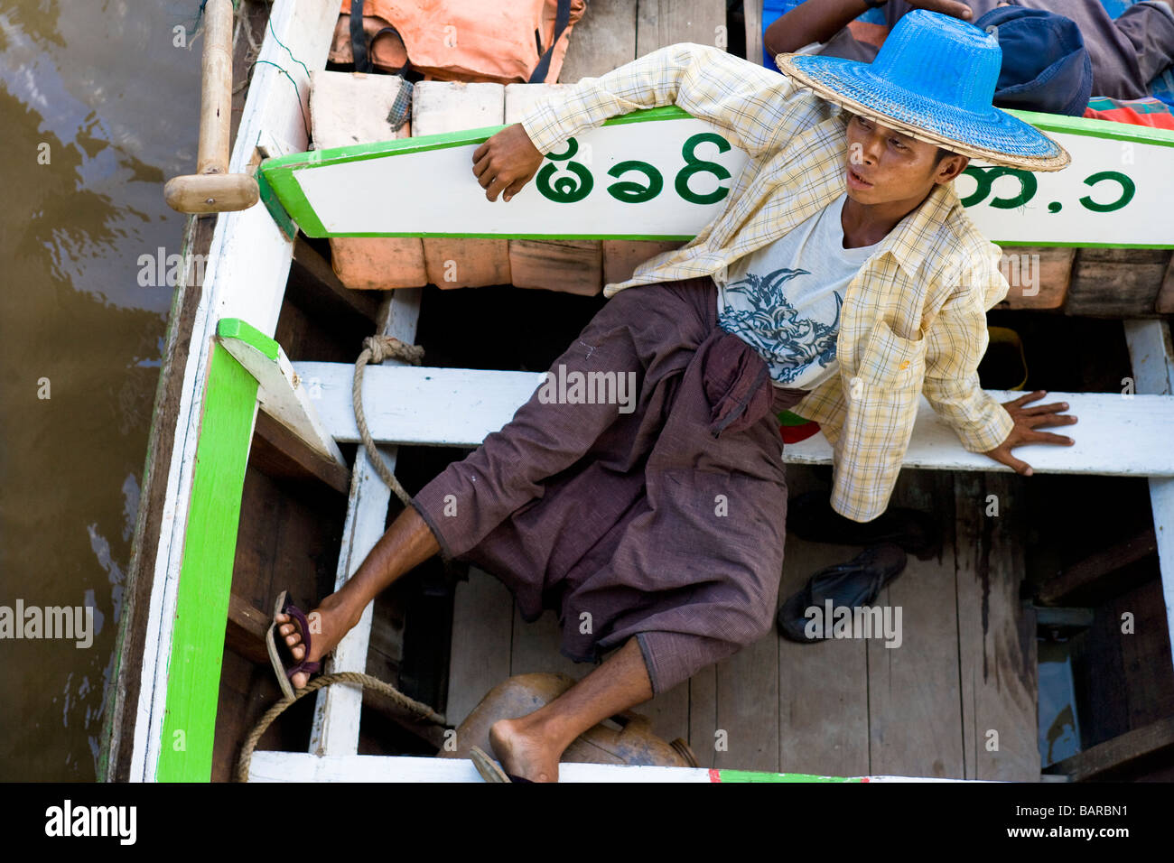 Burmese man relaxes on a boat Stock Photo - Alamy