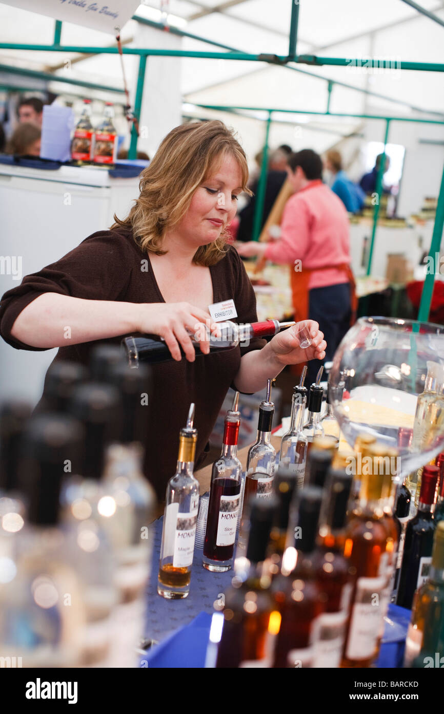 Woman pouring a sample of a liqueur at a food festival Stock Photo - Alamy