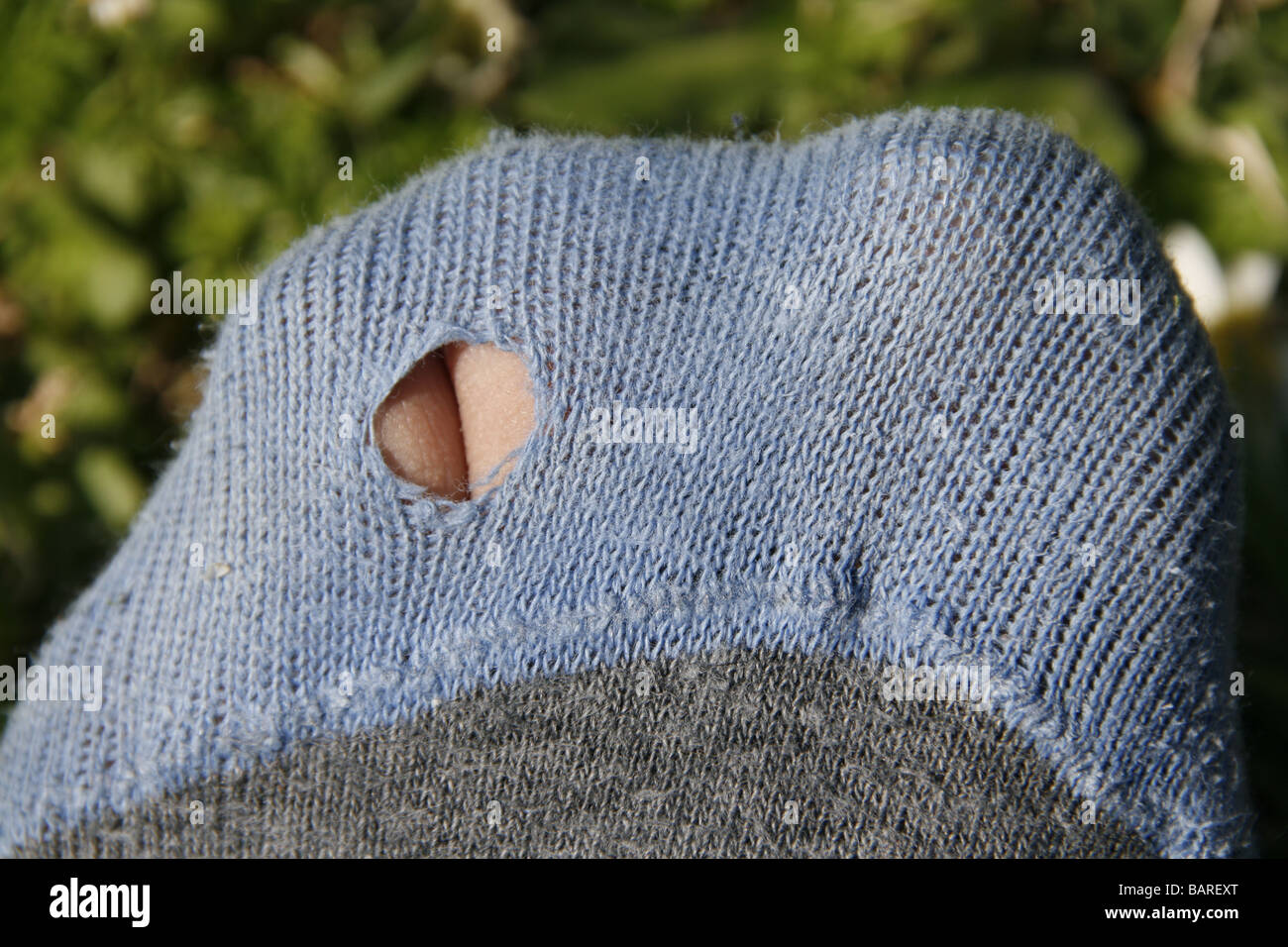person with hole in sock standing in field Stock Photo - Alamy