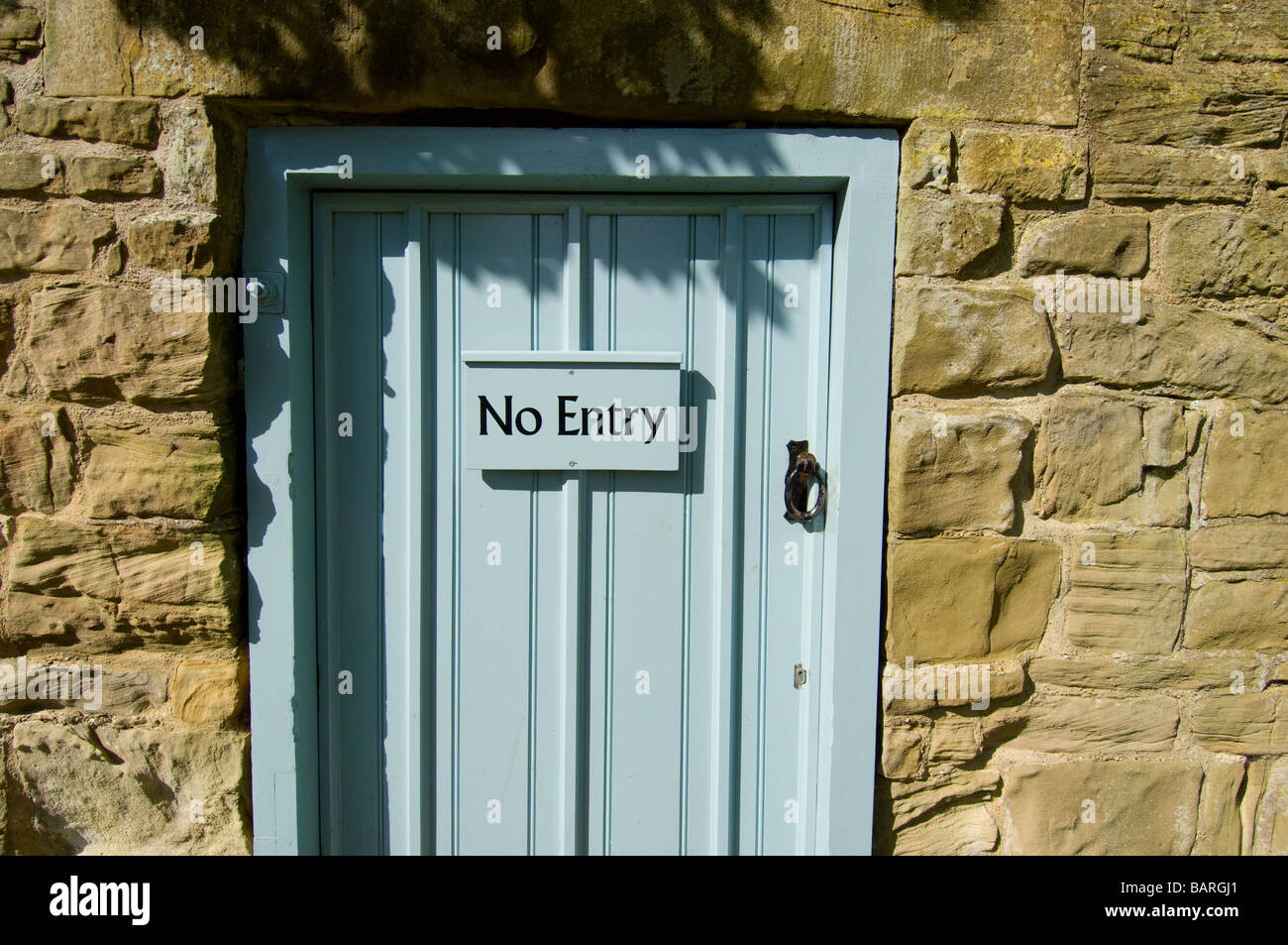 No entry sign mounted to a light blue door and old style door latch ...