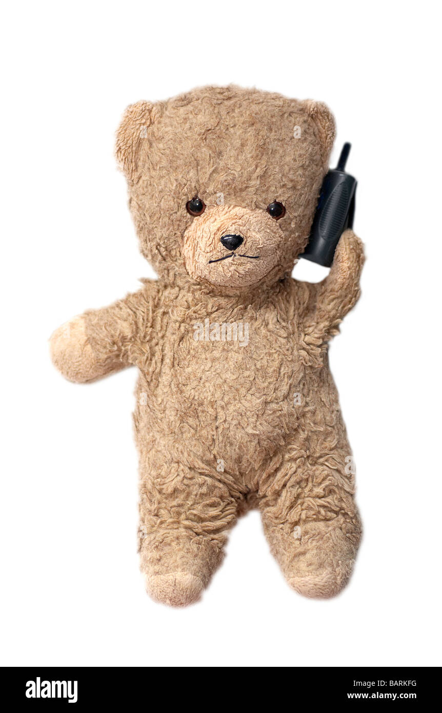 photo of a teddybear holding a phone isolated on a white background ...