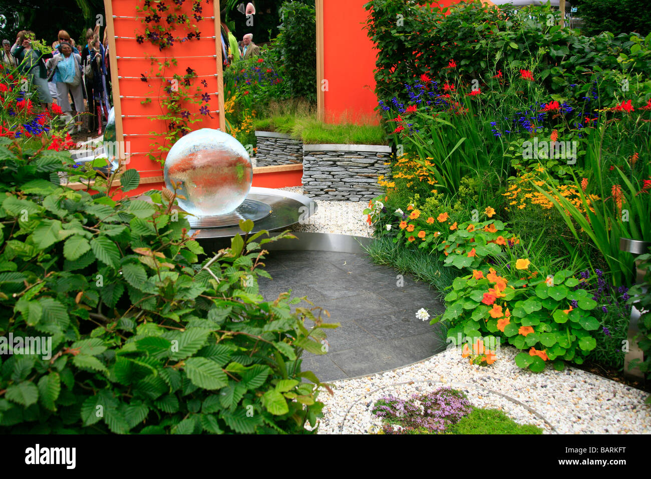 Large glass orb water feature on paved circle surrounded by a mirrored ...