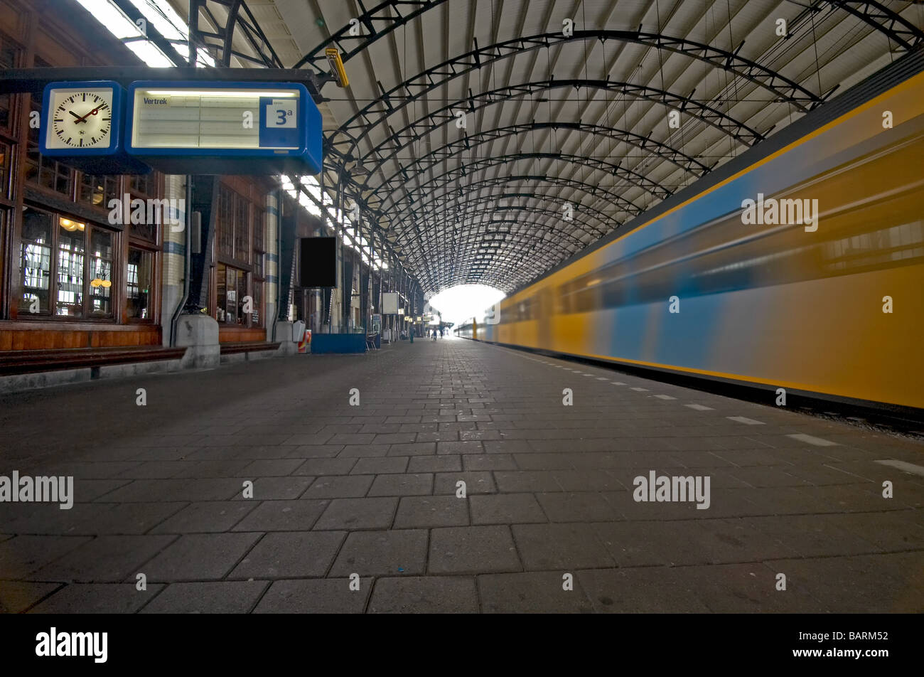 A train station in the netherlands with train in motion Stock Photo - Alamy