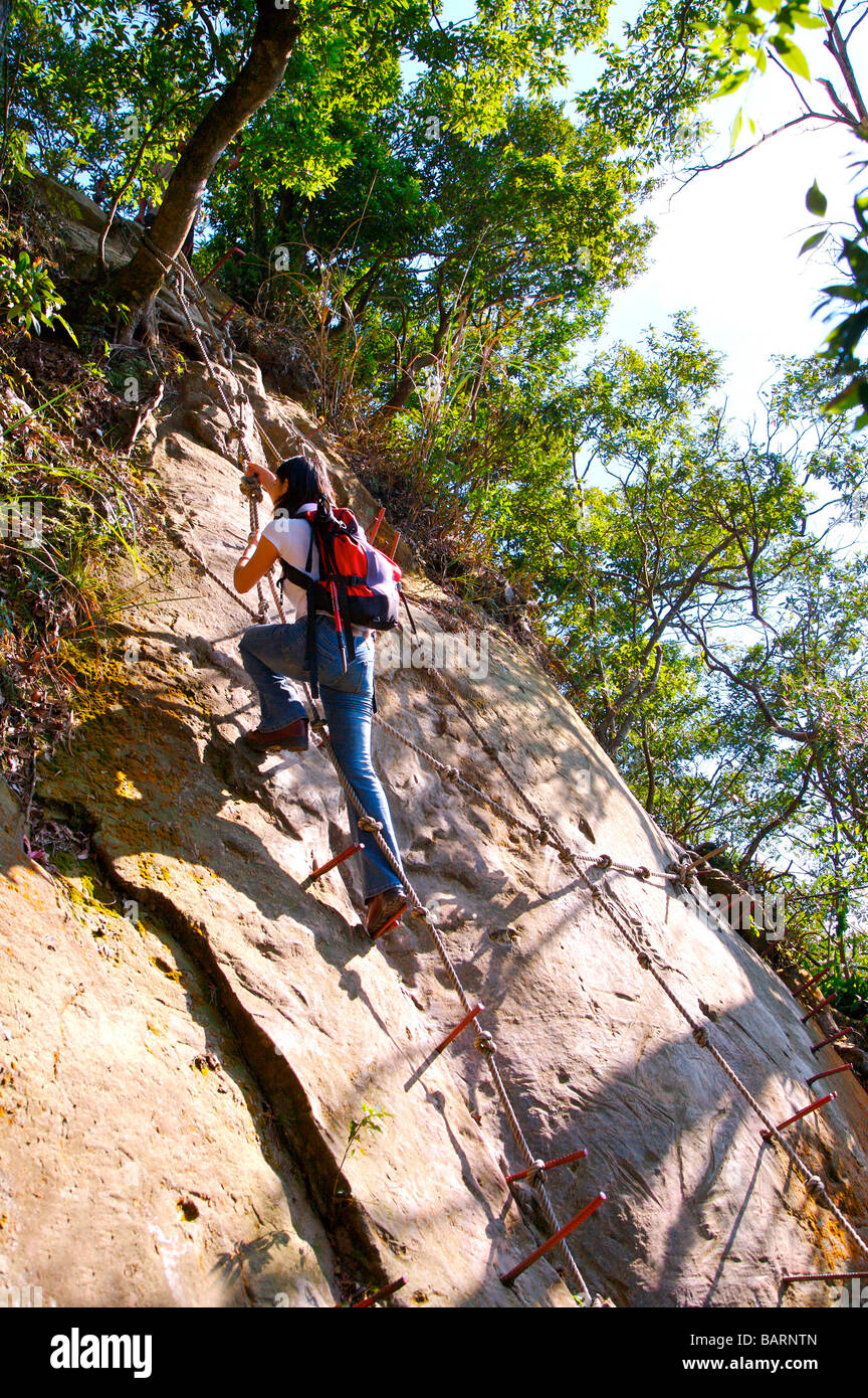 Young woman climbing rock side view Stock Photo - Alamy