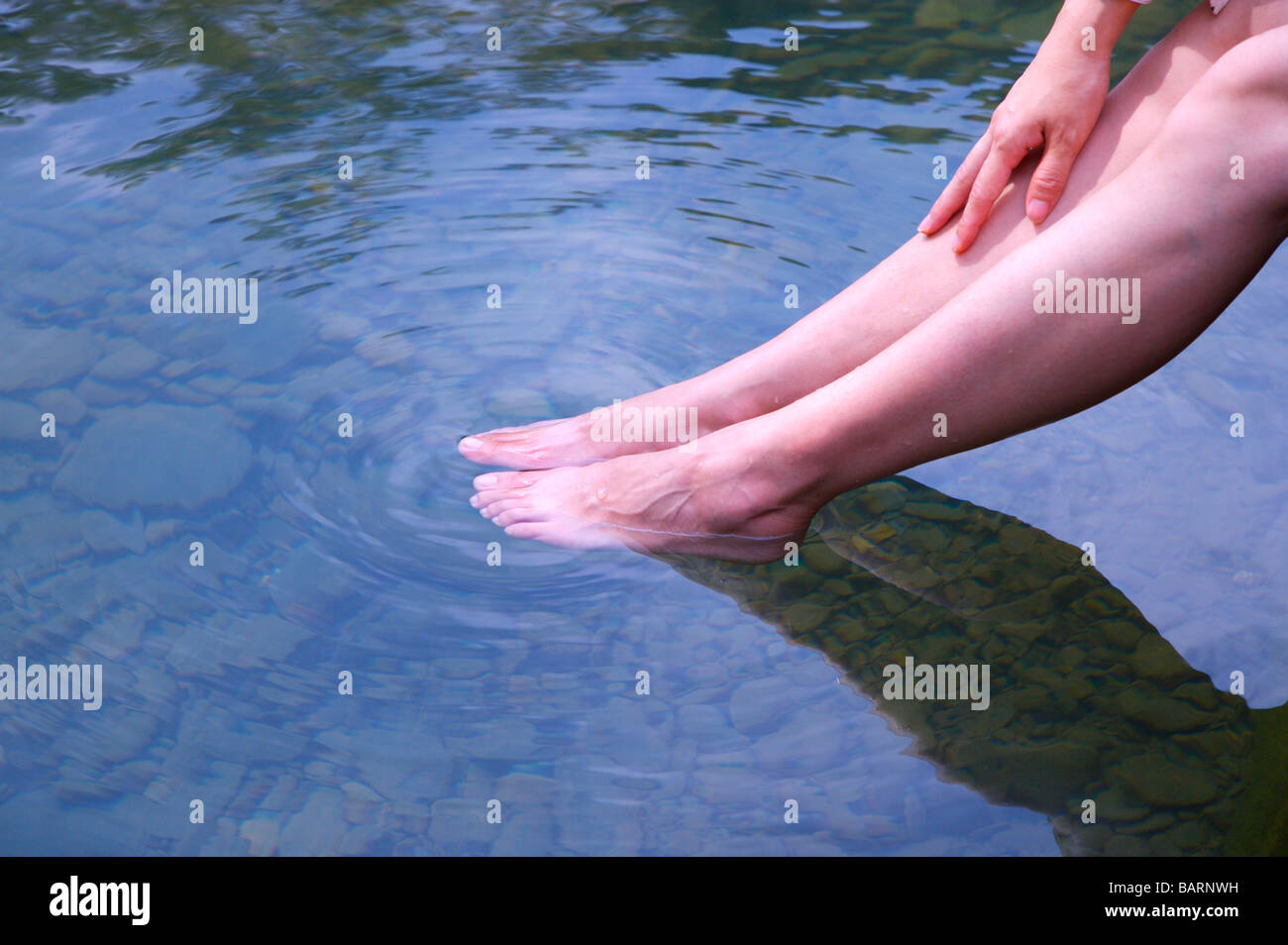 Young woman soaking feet in river low section Stock Photo - Alamy