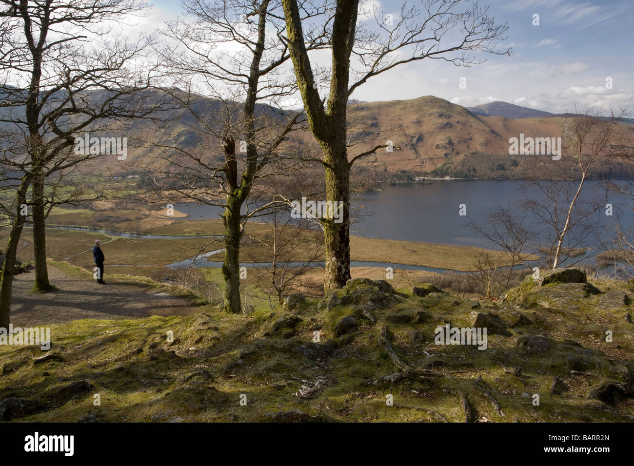 A tourist looks over Derwentwater at Surprise View in the Lake District ...