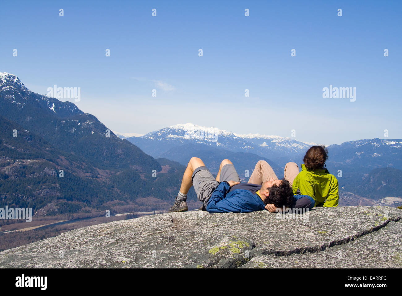 Two hikers resting on top of a mountain Stock Photo - Alamy