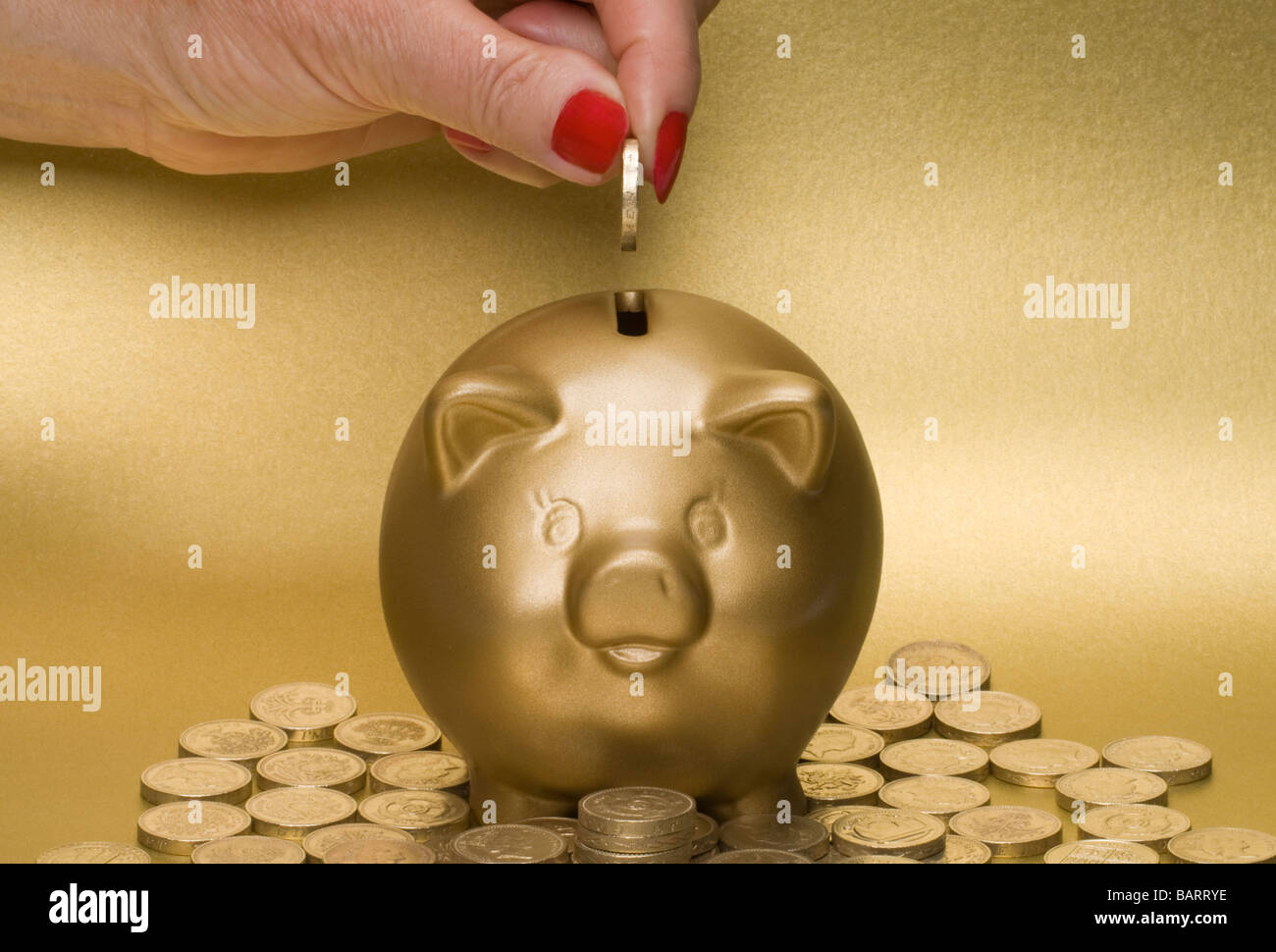 British pound coin being saved in a piggy bank Stock Photo - Alamy