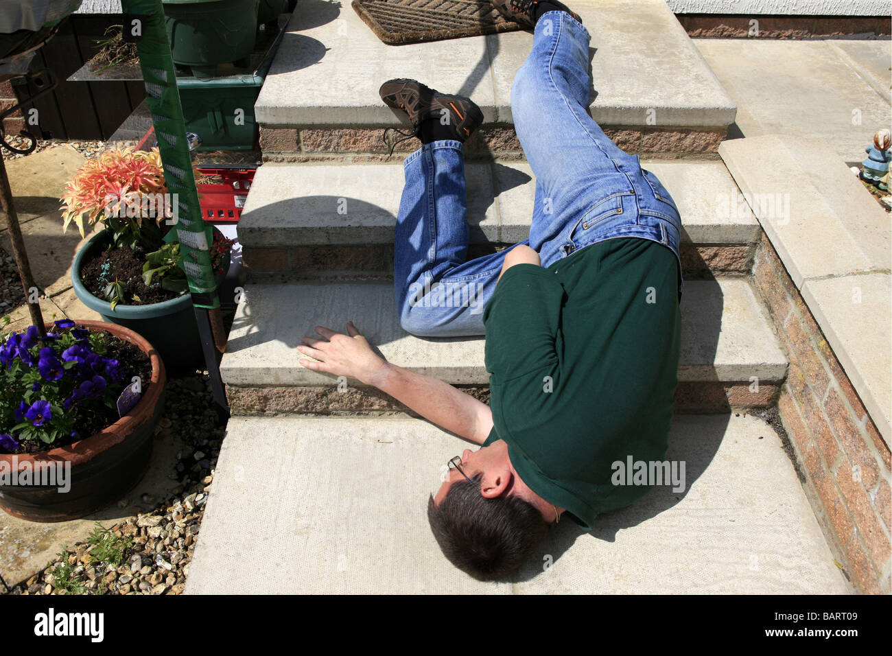 A man having fallen down a flite of stairs having slipped on a doormat ...