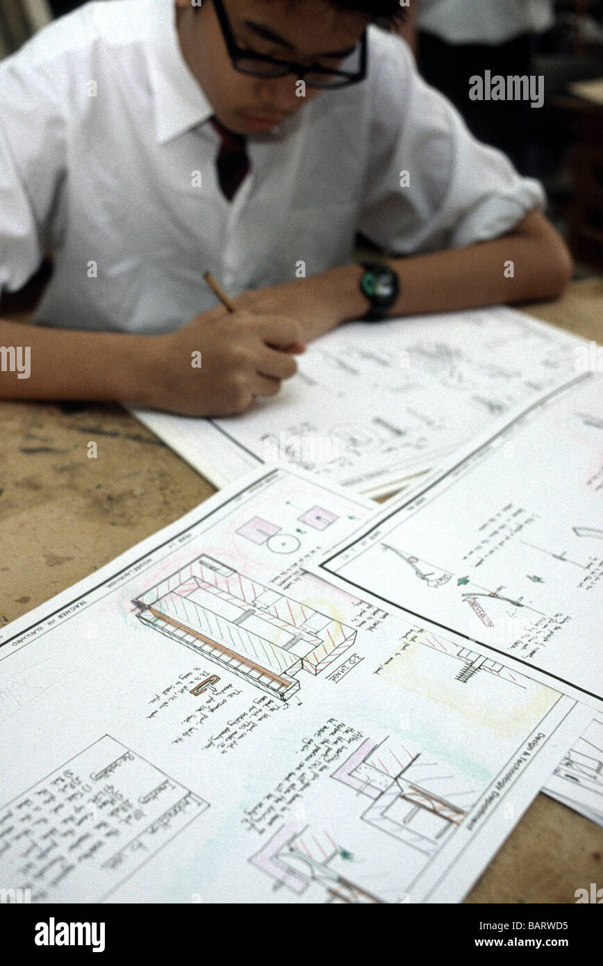 Secondary school boy working on technical drawings in the classroom ...