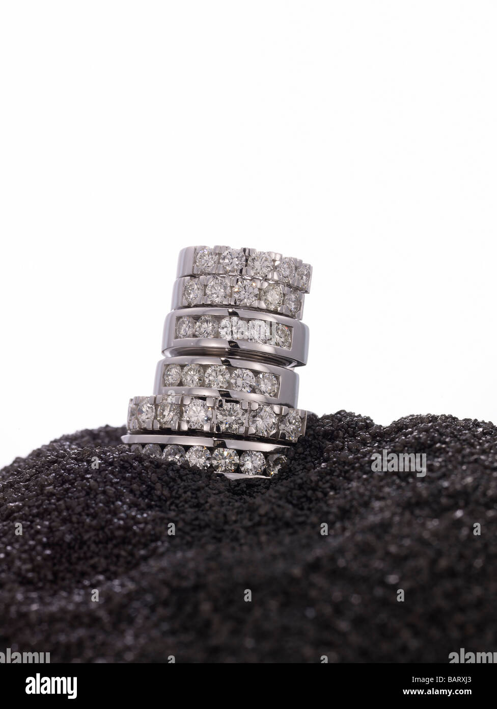 Stacked Diamond rings on black sand Stock Photo - Alamy