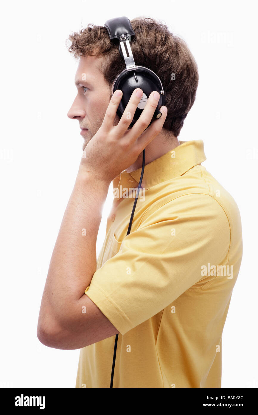 Young man wearing headphones, side view, portrait Stock Photo - Alamy