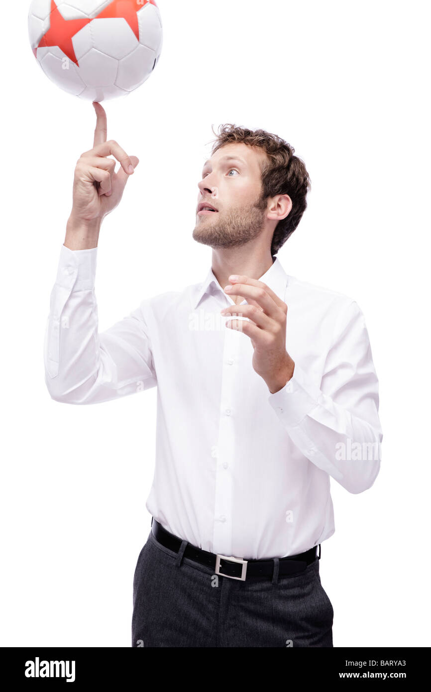 Young man balancing soccer ball on his finger, portrait Stock Photo - Alamy