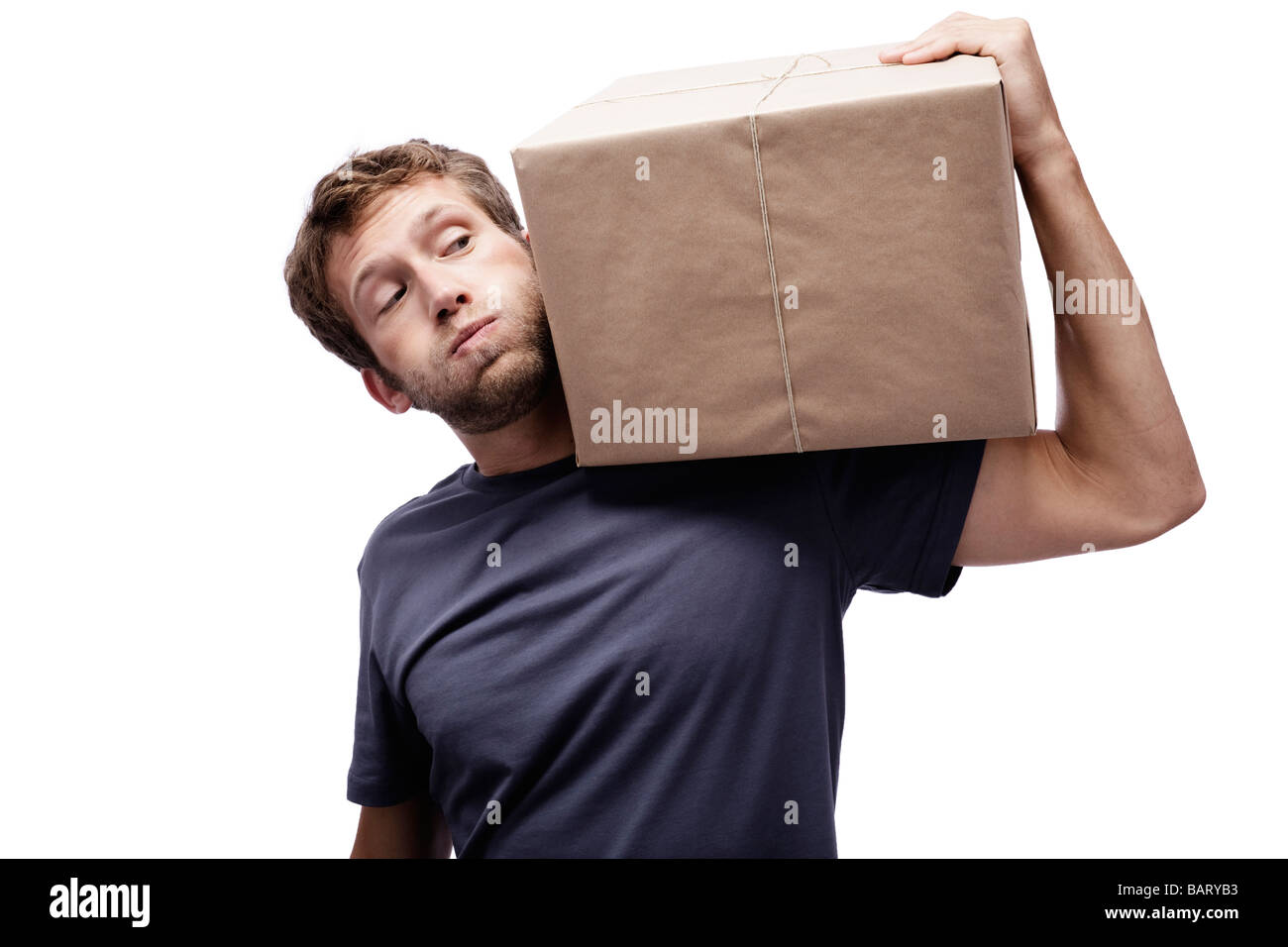 Young man carrying packet on his shoulders, portrait Stock Photo - Alamy