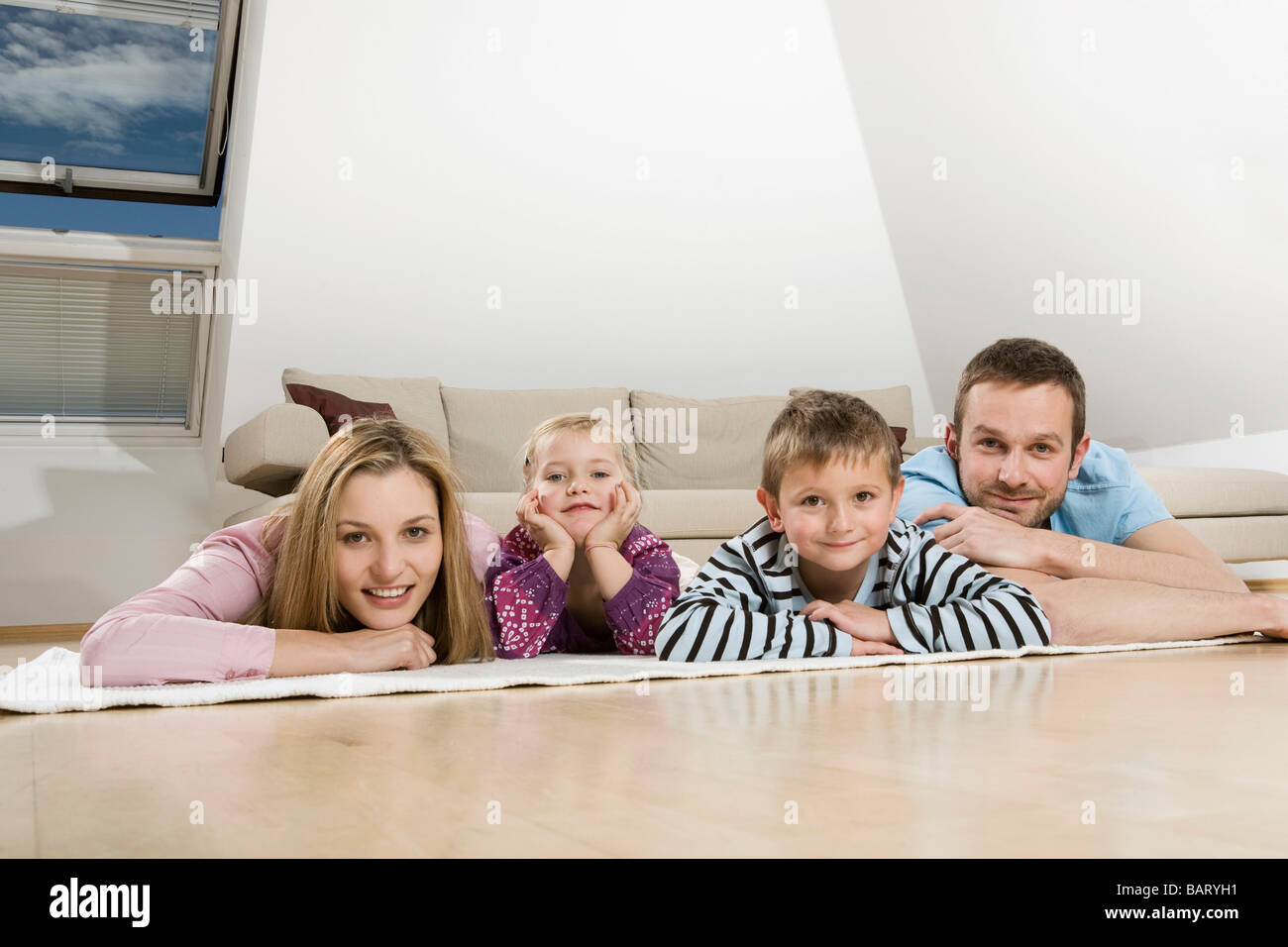 Family relaxing at home, smiling Stock Photo - Alamy