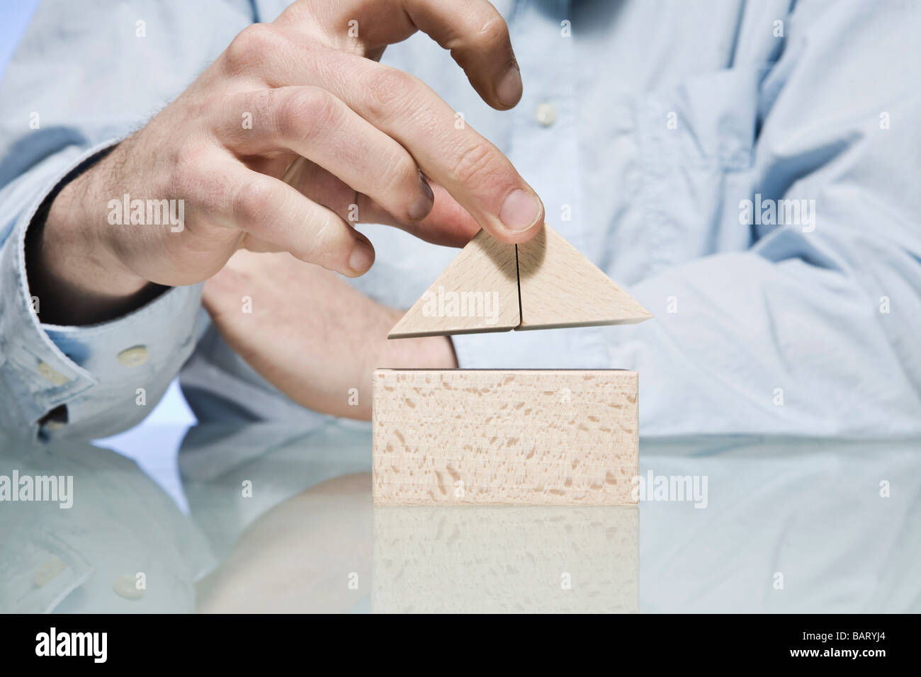 Person building house with building bricks, close up Stock Photo - Alamy