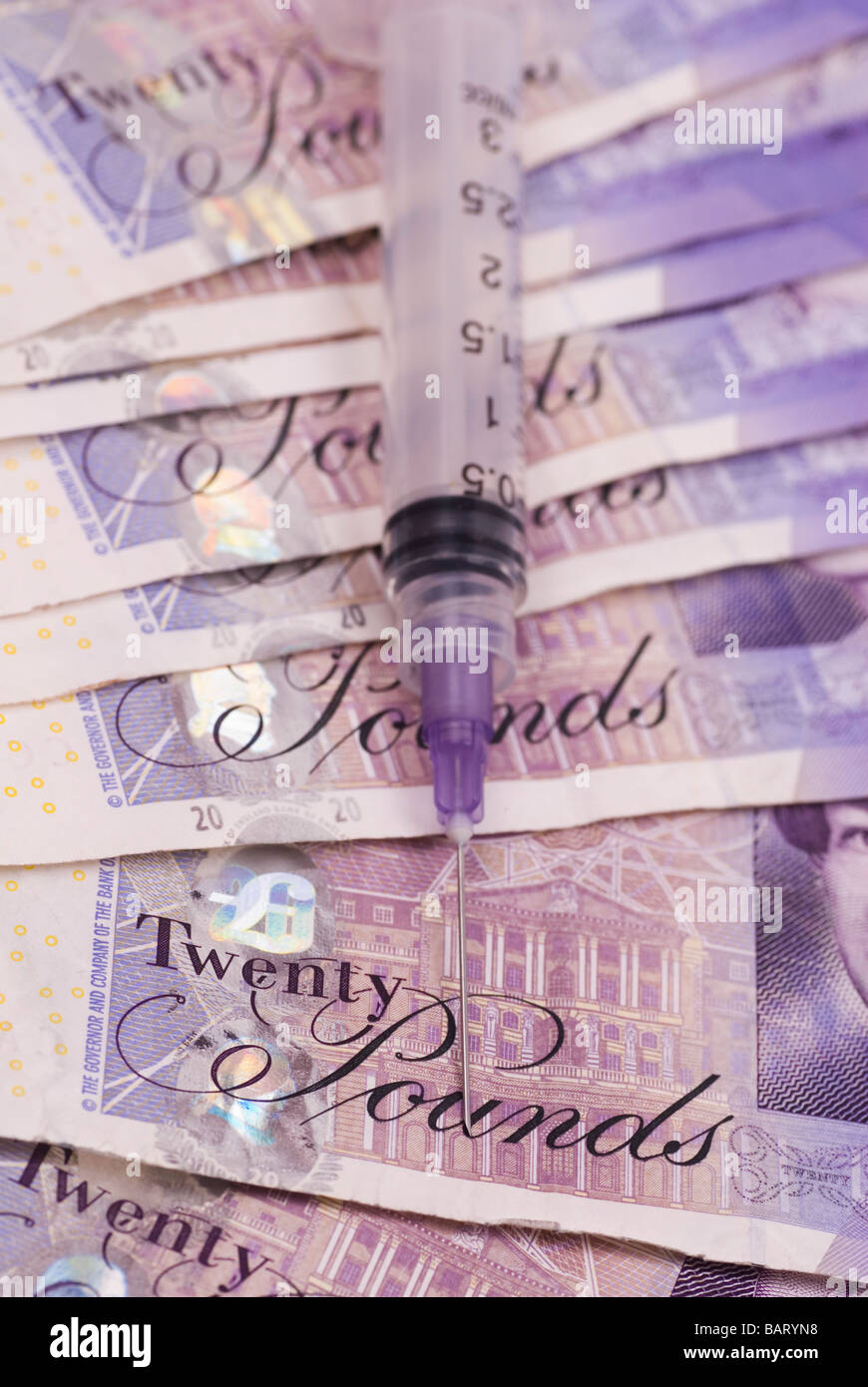 Medical injection over a pile of British money Stock Photo - Alamy