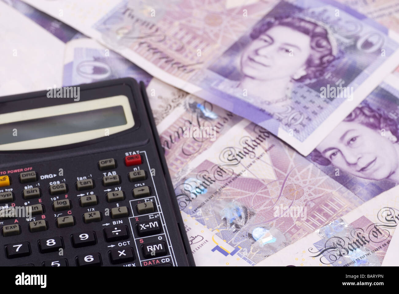 Calculator of a pile of British money Stock Photo - Alamy