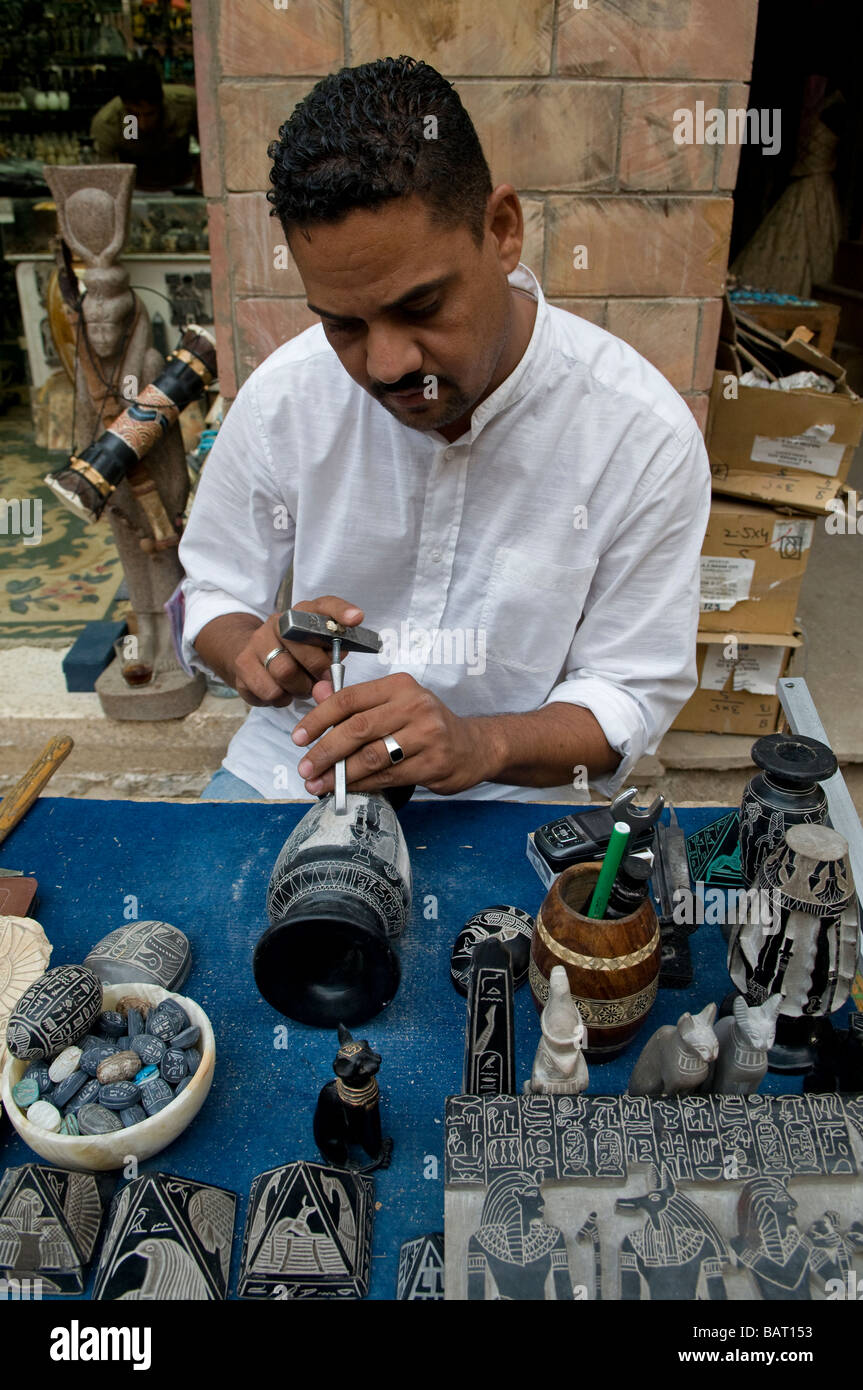 Vendor carving handicraft souvenirs in Aswan Souk a colorful bazaar ...