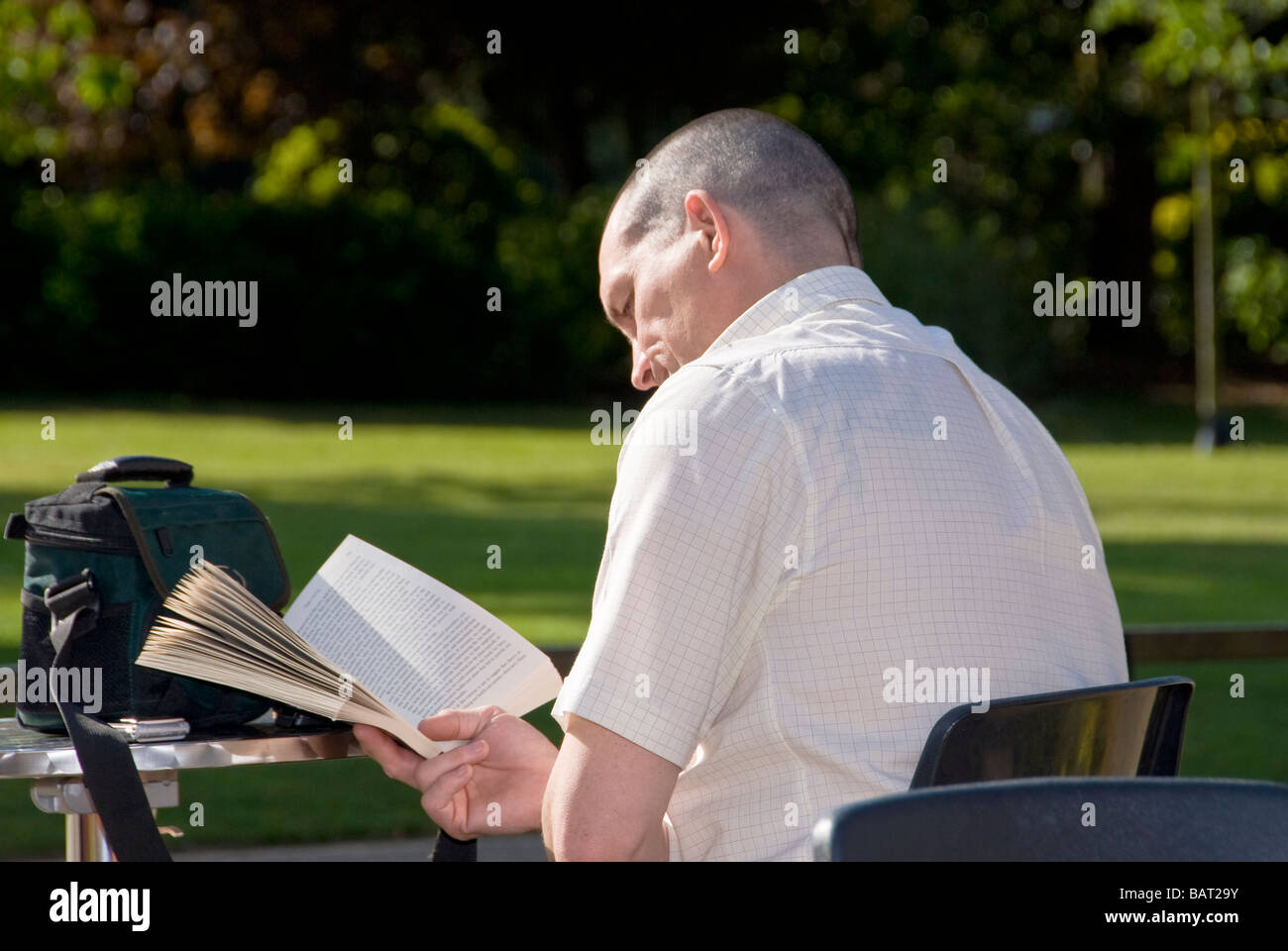 Man reading a book outside Stock Photo - Alamy