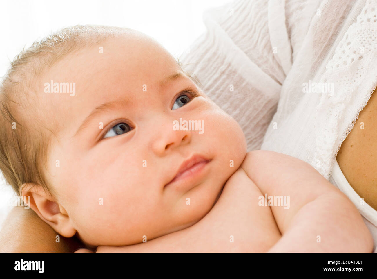 baby looking up at mother Stock Photo - Alamy