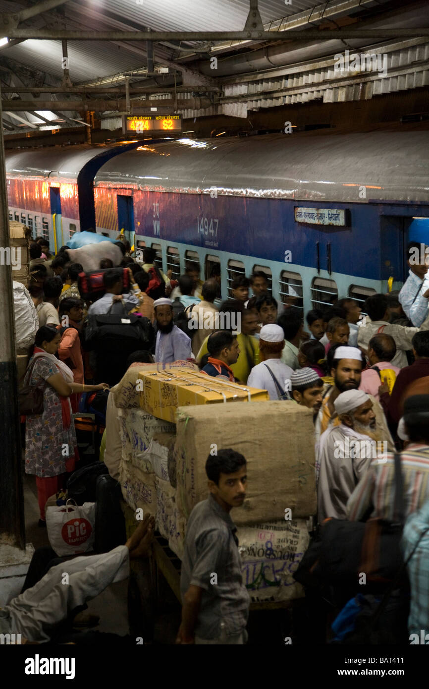 Passengers board trains on the platform while freight is transferred ...