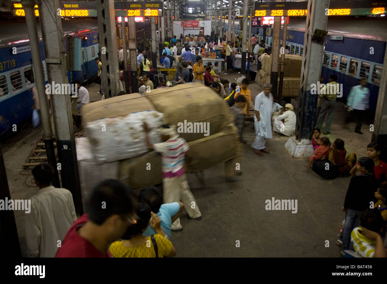 Passengers board trains on the platform while freight is transferred ...