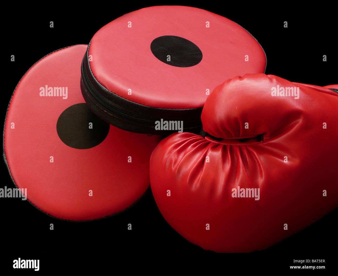 A pair of punching mitts with a boxing glove on a black background ...