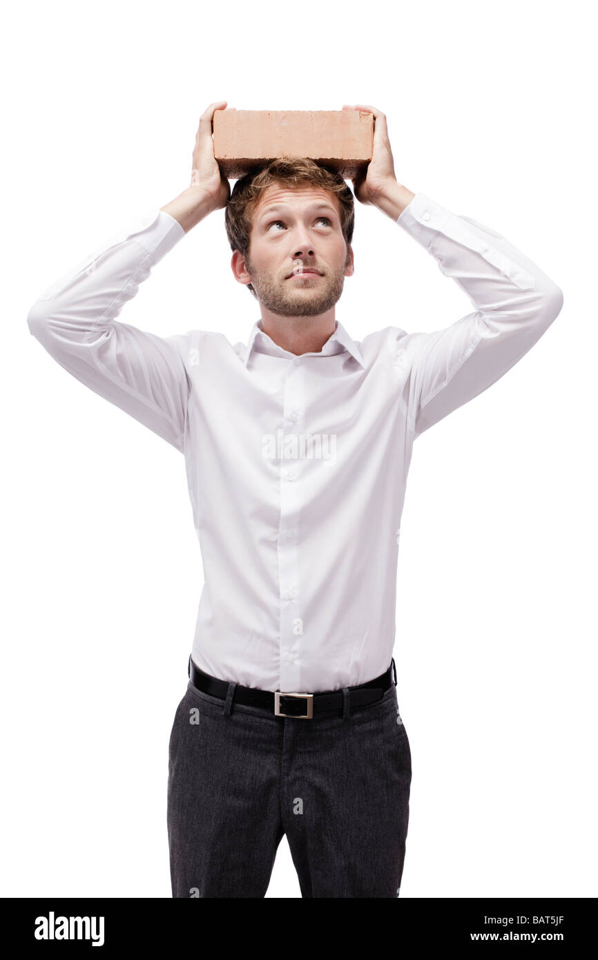 Young man balancing brick on head, portrait Stock Photo - Alamy