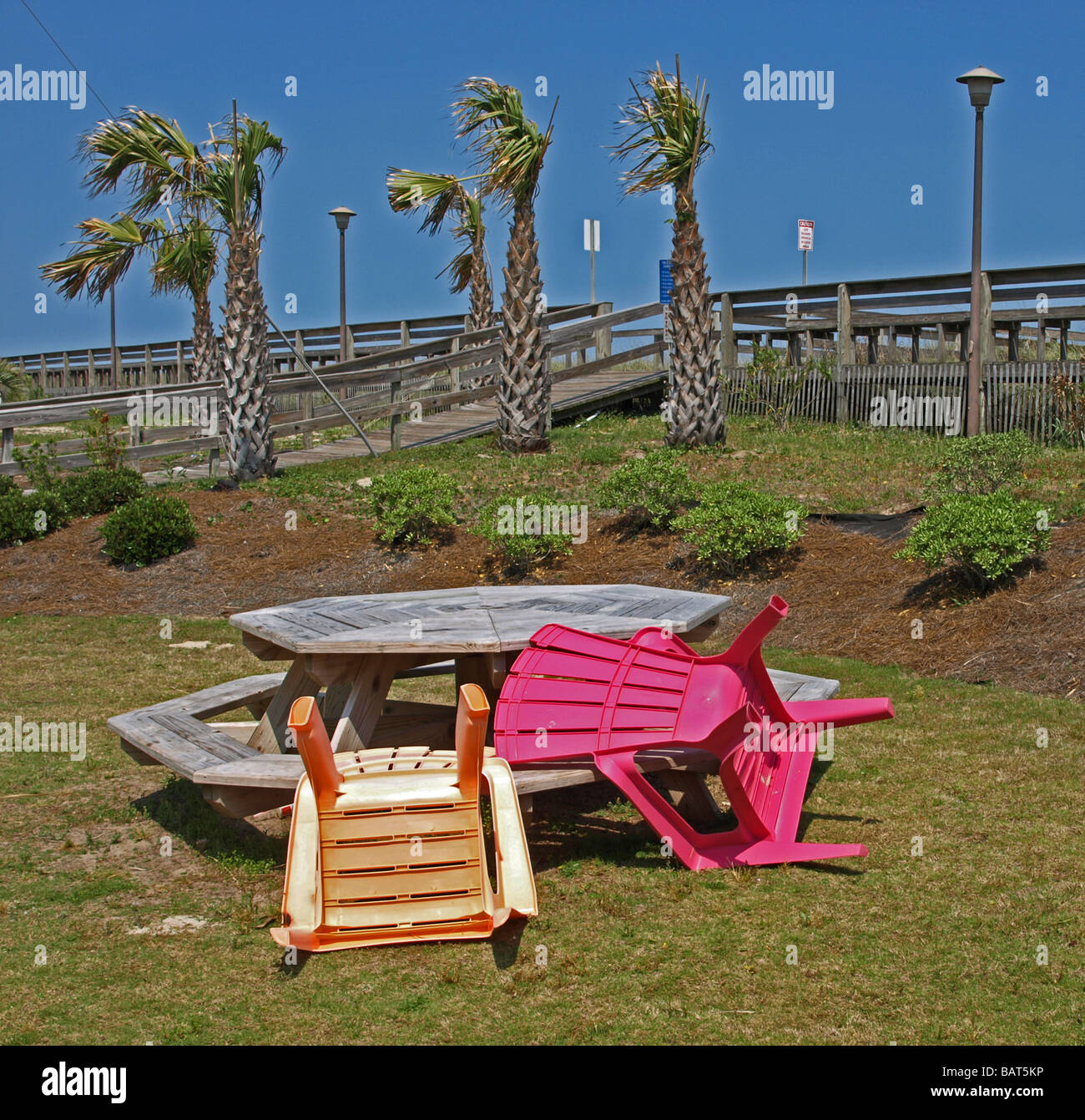 beach access scene with picnic table and bright plastic seating chairs ...