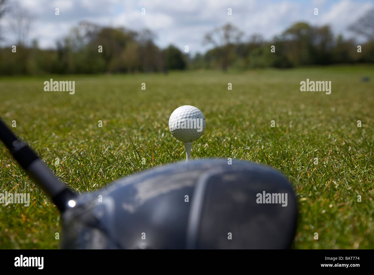 used golf ball sitting on the tee with driver club behind at the start ...