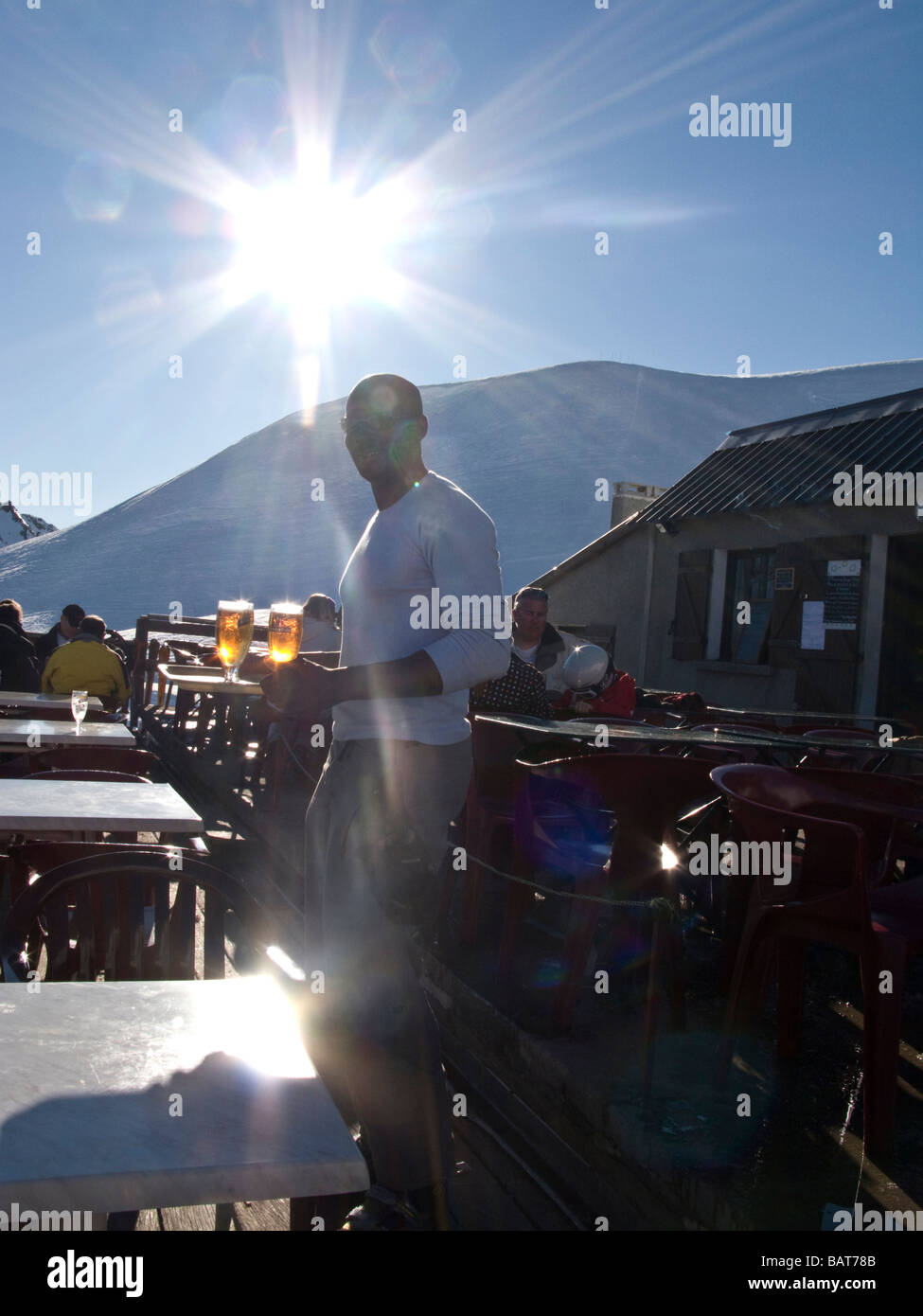 Coloured Waiter serving beer at Ski Resort, France Stock Photo - Alamy
