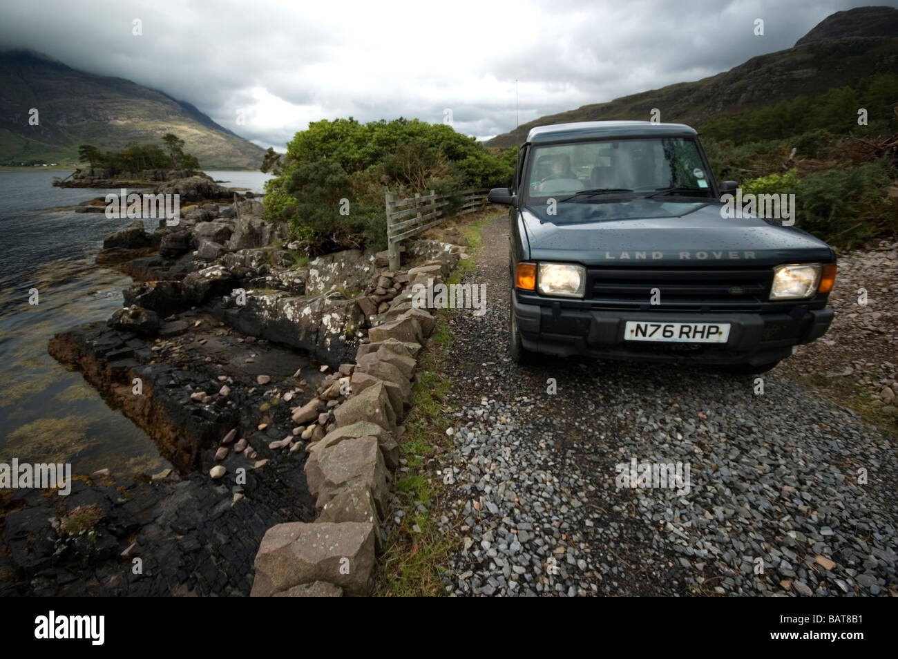 Land Rover Discovery on shores of Loch Torridon, Scotland in rainy ...