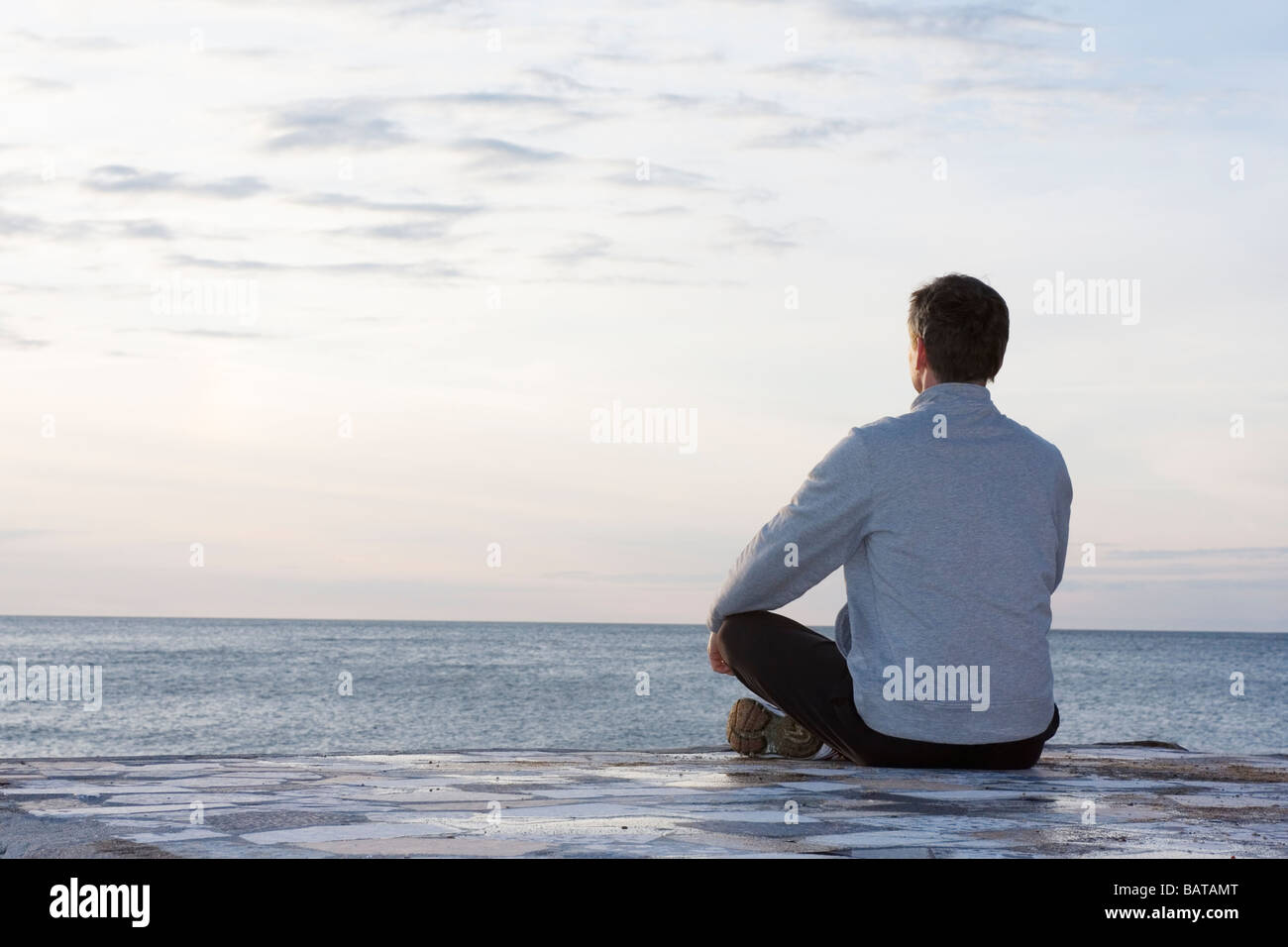 Man relaxing after running at the sea Stock Photo - Alamy