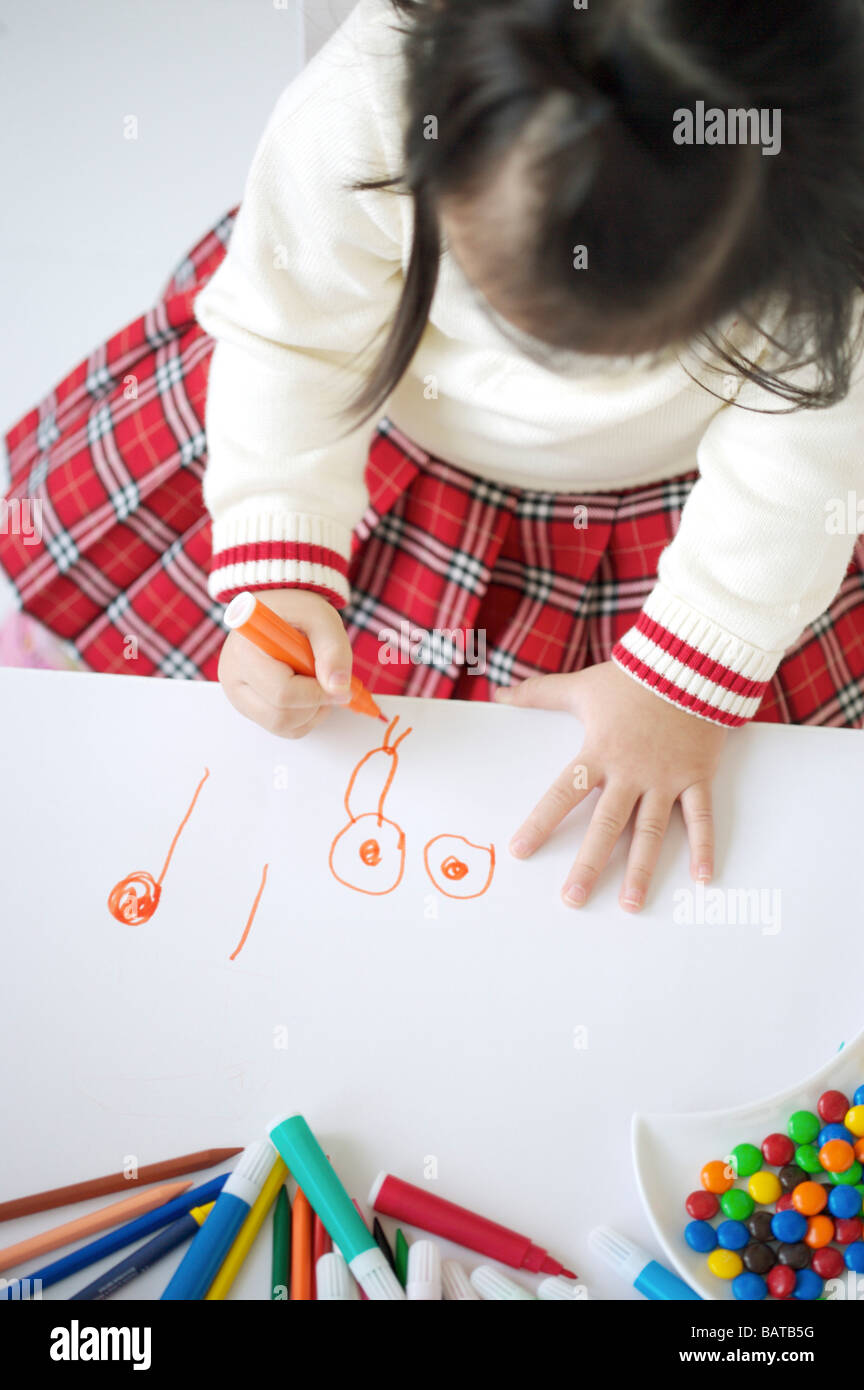 Girl drawing on paper Stock Photo - Alamy
