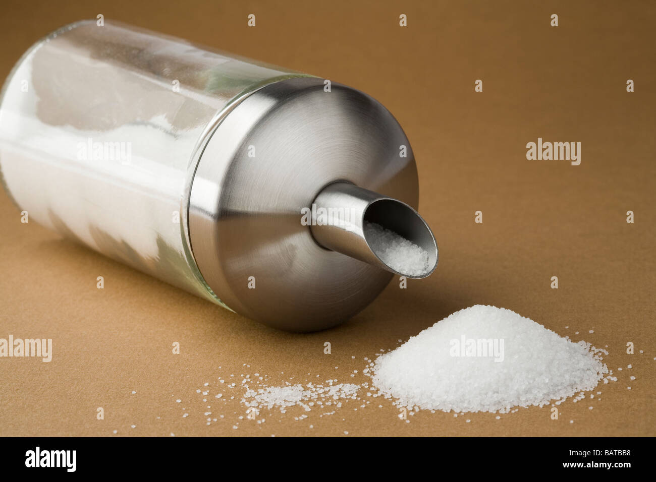 A sugar dispenser with sugar spilling out Stock Photo - Alamy